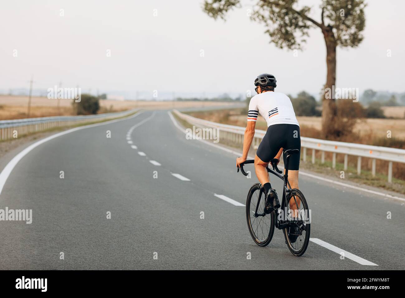 Back view of active man riding bike on fresh air Stock Photo - Alamy