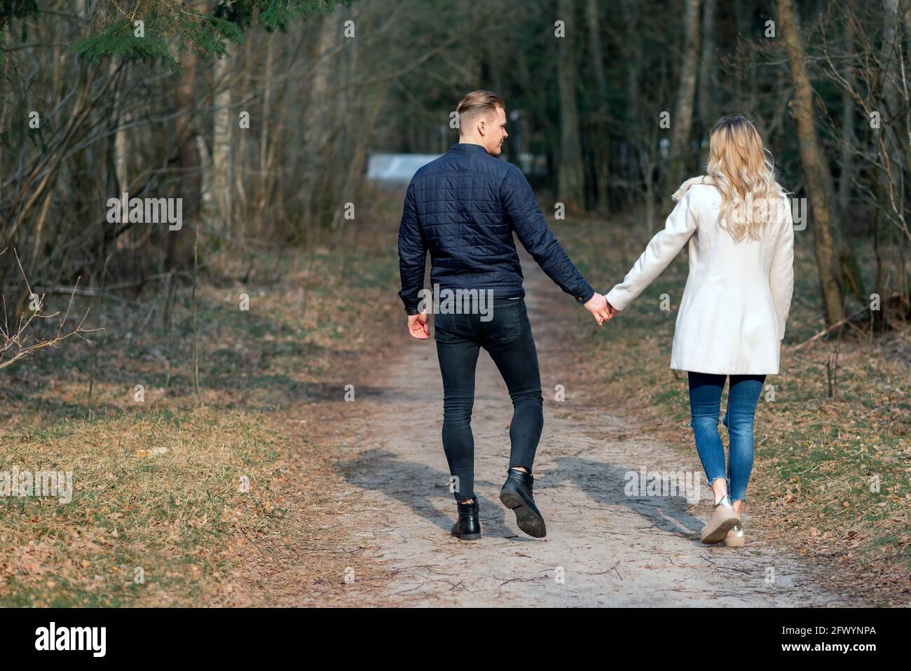 Beautiful loving couple going for a walk in a forest in the spring ...