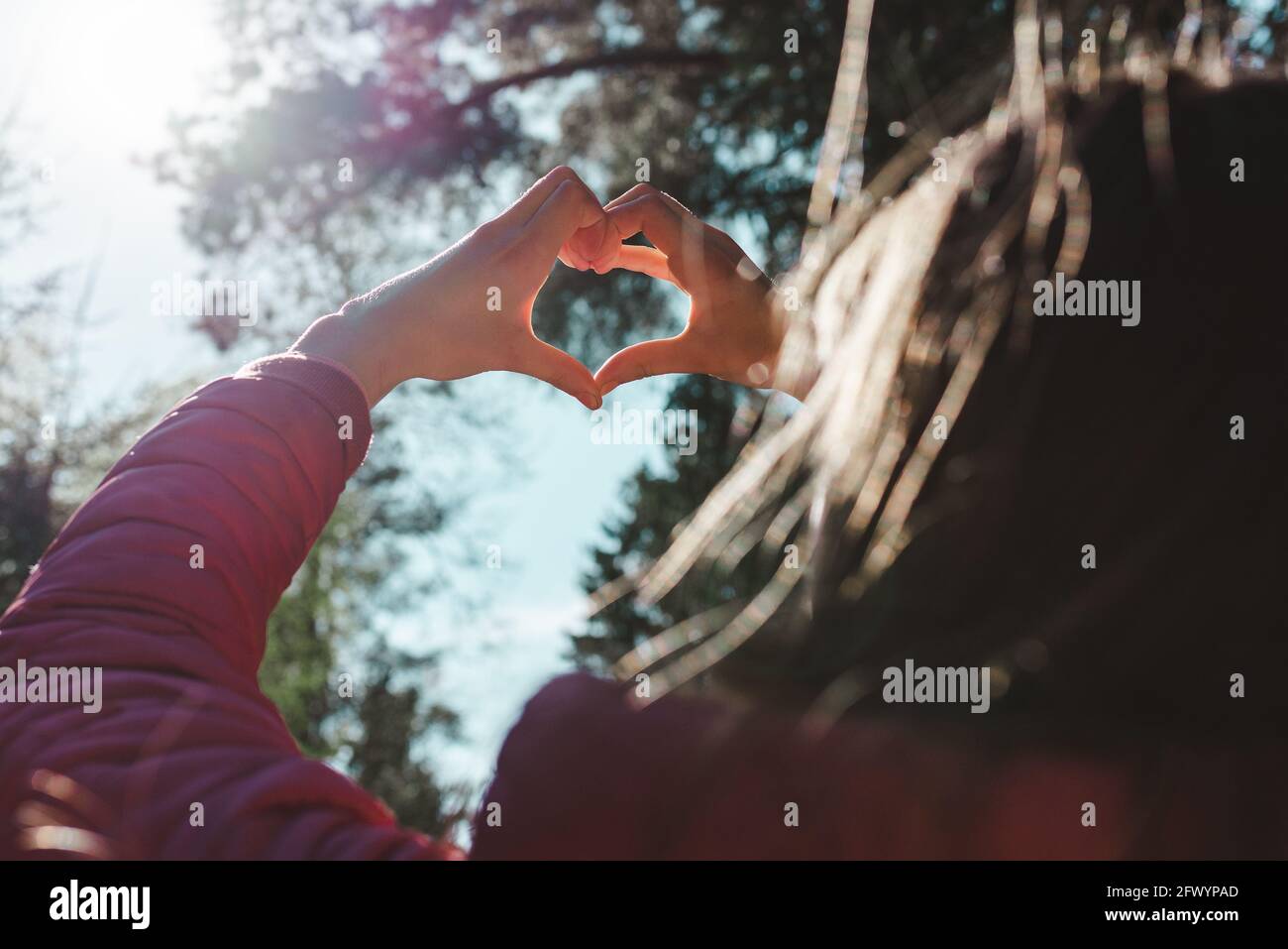 Hands in heart shape. Teenage girl hands heart shape on against blurry ...
