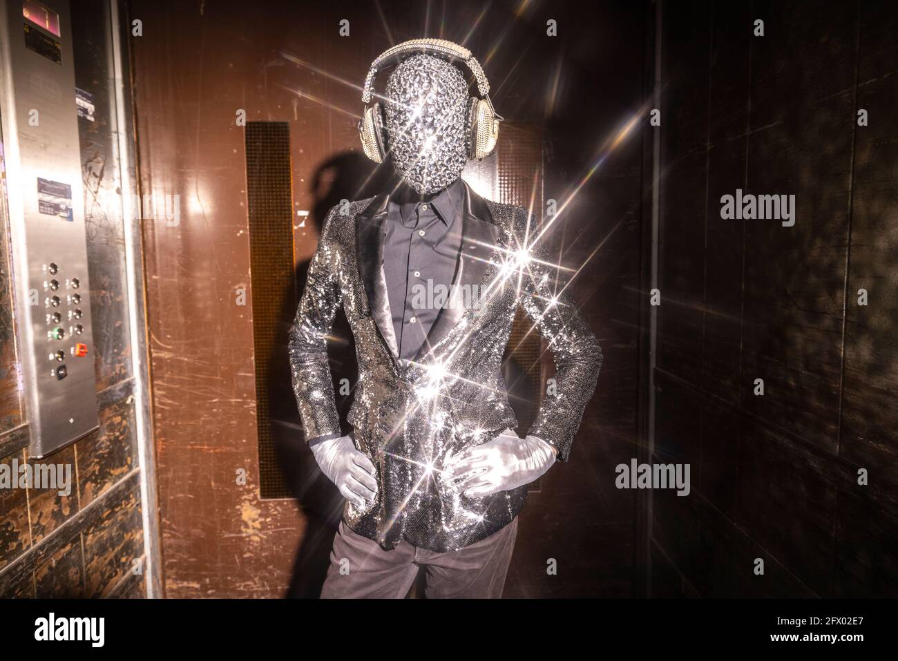 Sparkle masked man dancing in a lift Stock Photo - Alamy