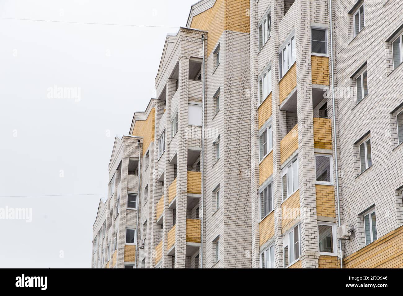 Residential high-rise building with yellow balconies. Against the ...