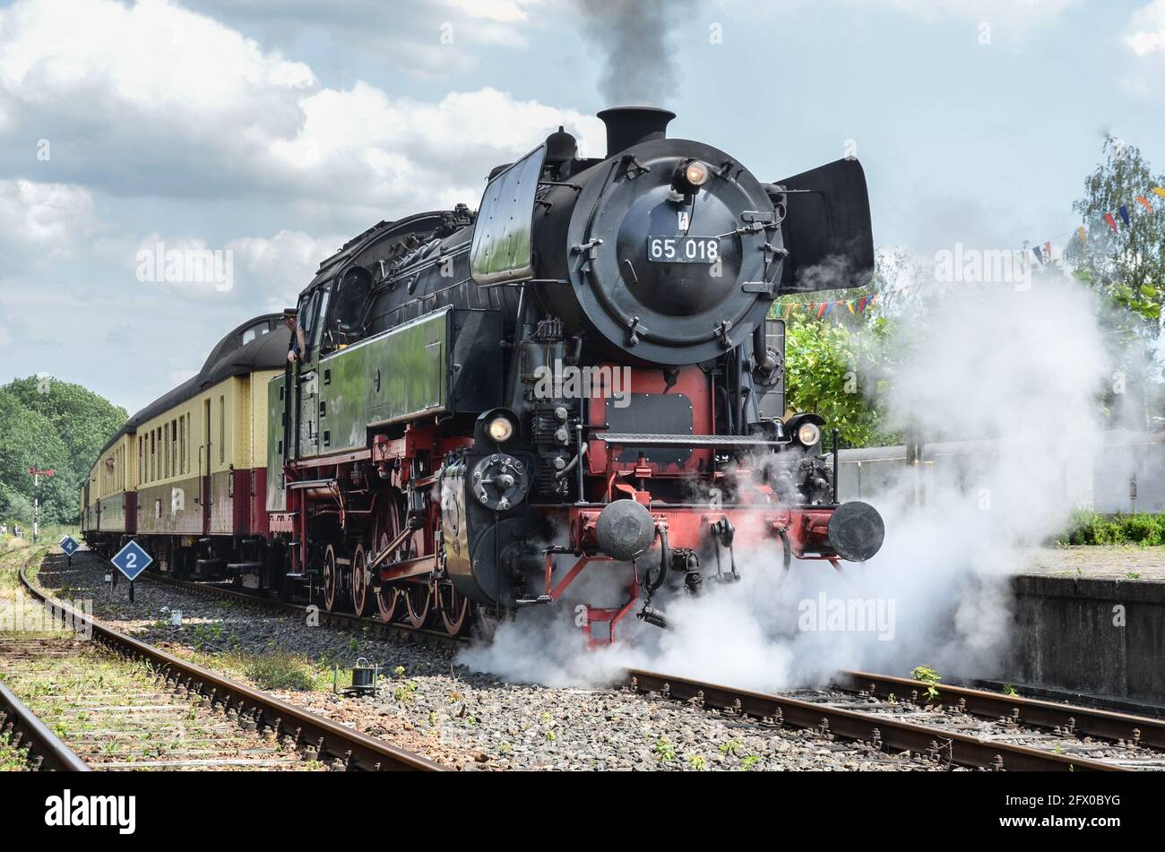 Steam Engine releasing steam during its departure from the station of ...