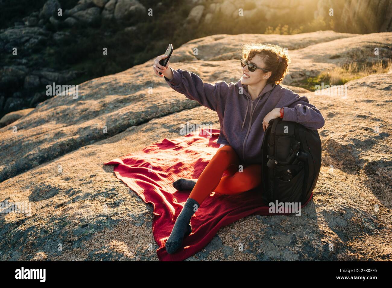 Joyful young female hiker with curly hair in casual outfit and ...