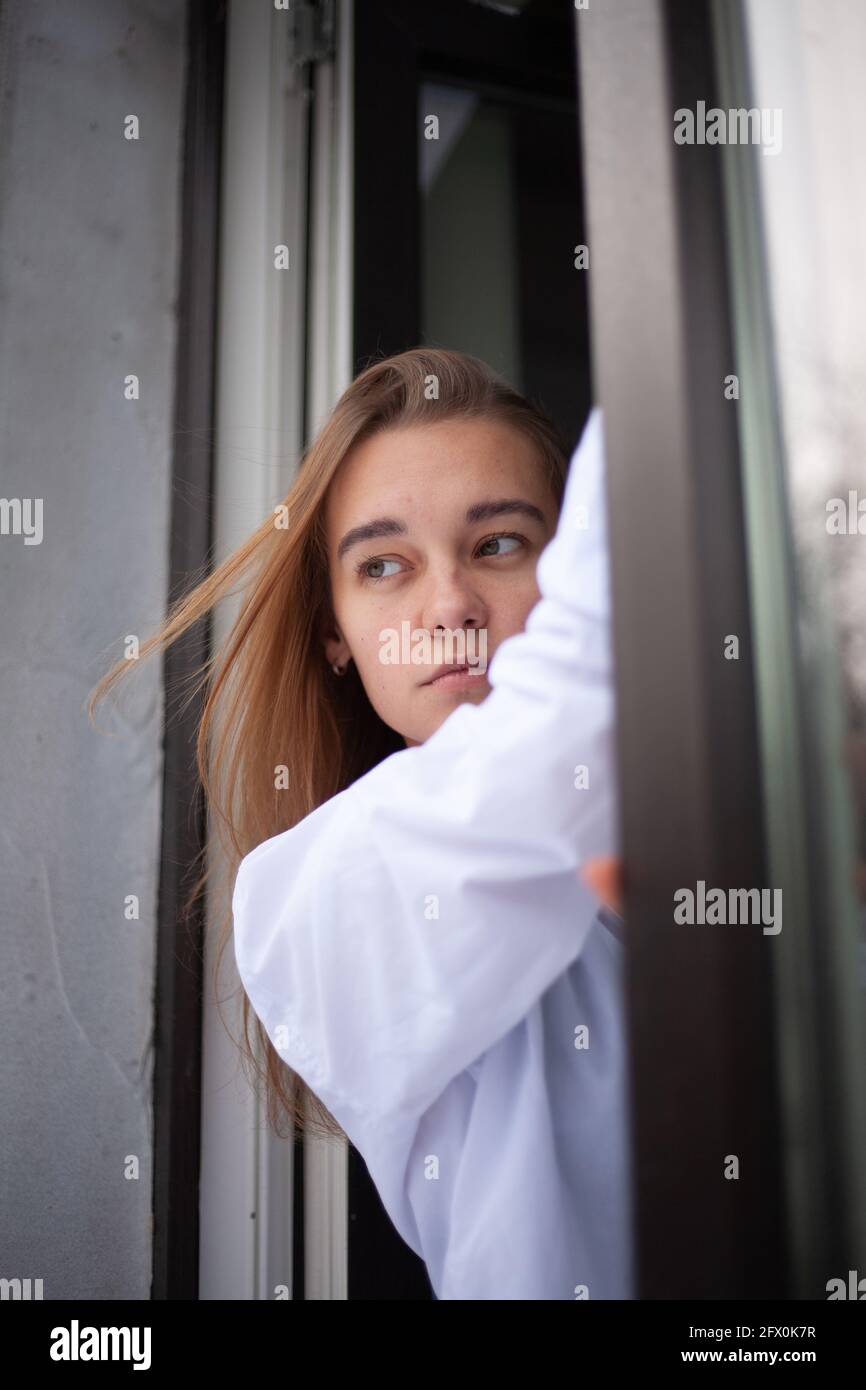 Portrait of a beautiful young blonde looking out of the window Stock ...