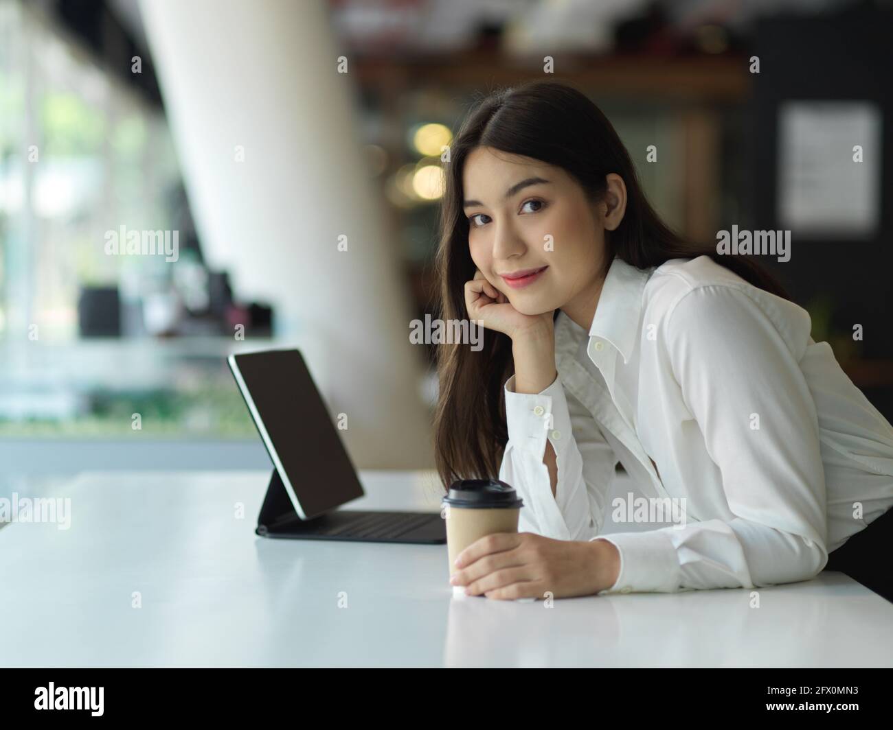 Side view of young beautiful businesswoman smiling with hand to cheek ...