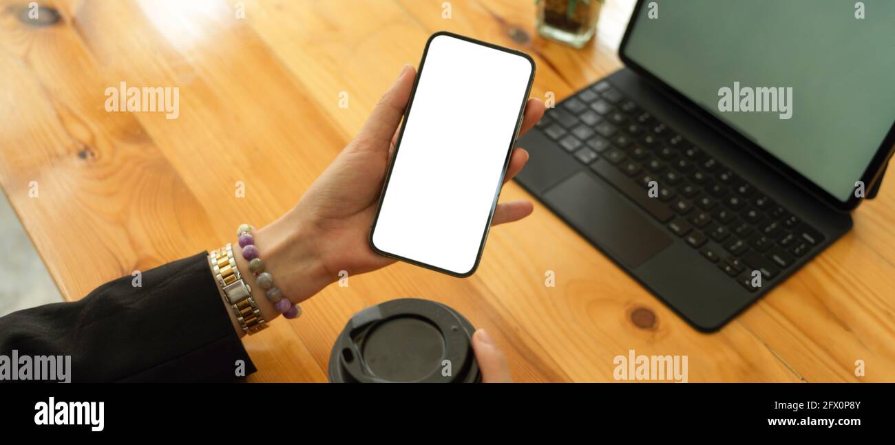 Top view of businesswoman hand holding smartphone and showing mock up ...