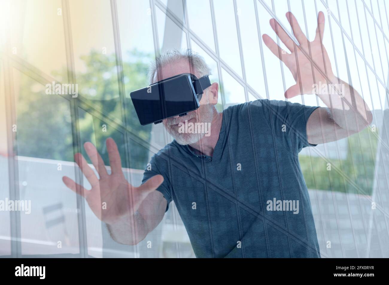 Senior man using a virtual reality headset, double exposure Stock Photo ...