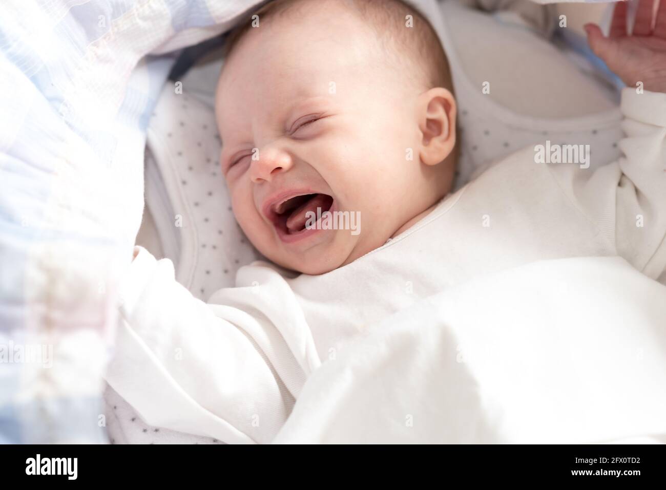 Little baby girl crying in her crib Stock Photo - Alamy