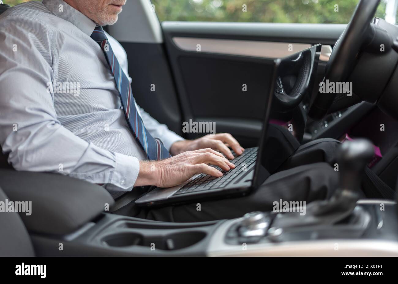 Businessman using a laptop in his car Stock Photo - Alamy