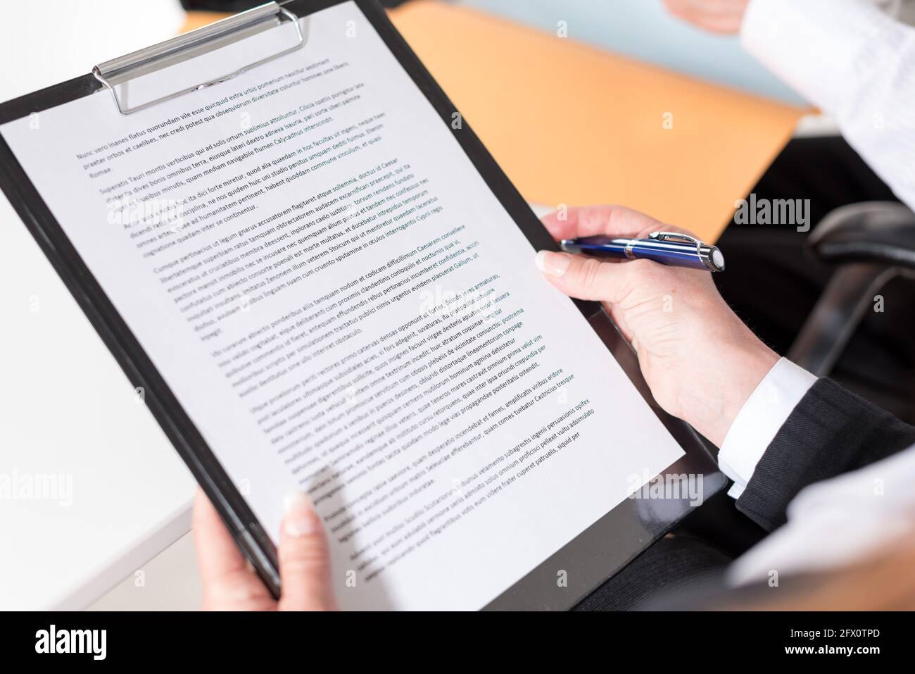Businesswoman reading a document at office Stock Photo - Alamy