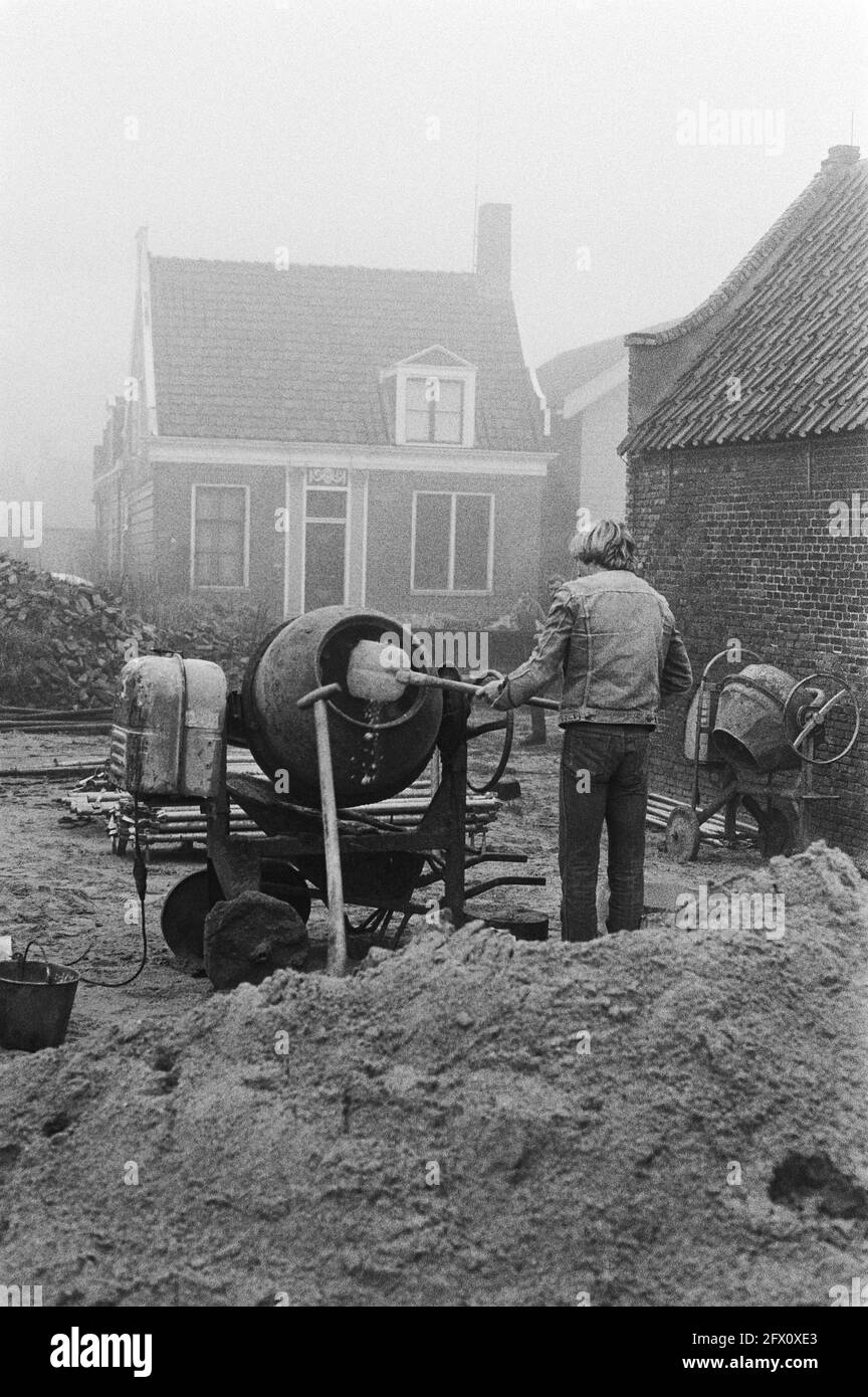 Construction worker working at a cement mixer, January 27, 1981, bricks ...