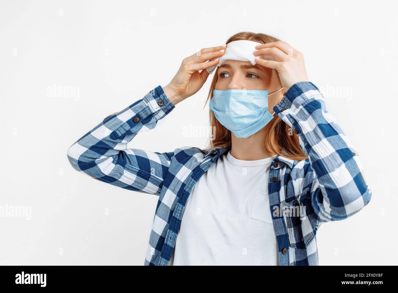 Young woman has a cold and high fever, she is checking her body ...