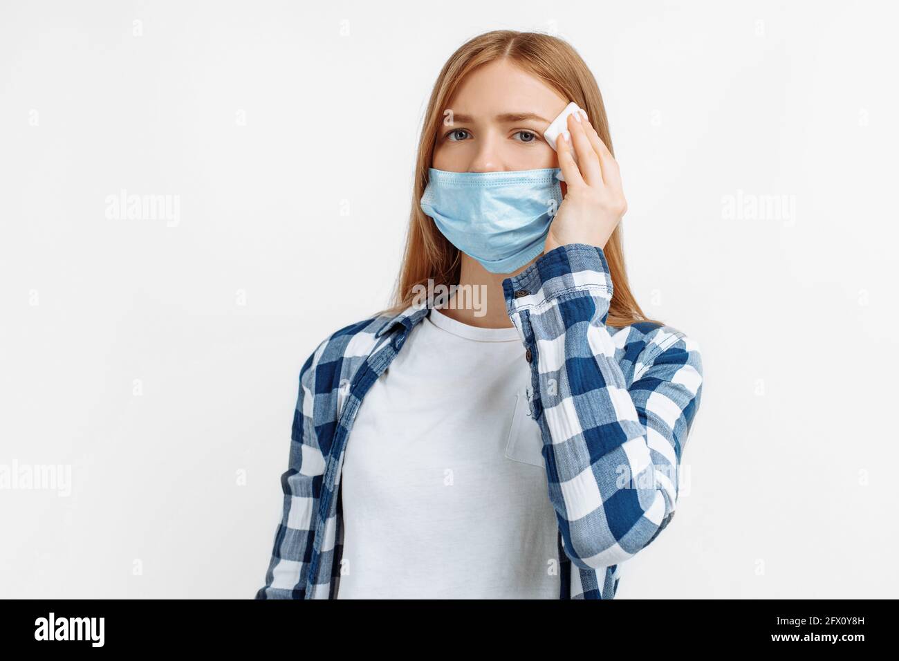Young woman has a cold and high fever, she is checking her body ...