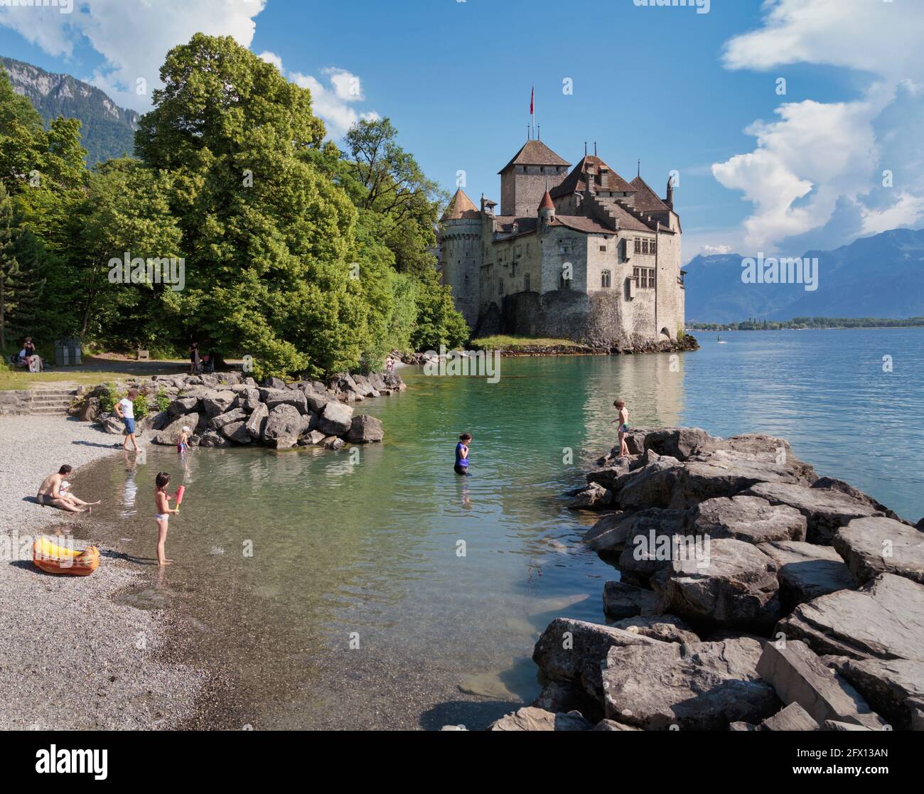 Sunbathers on the shore of Lake Geneva (Lac Leman) beside the Chateau ...