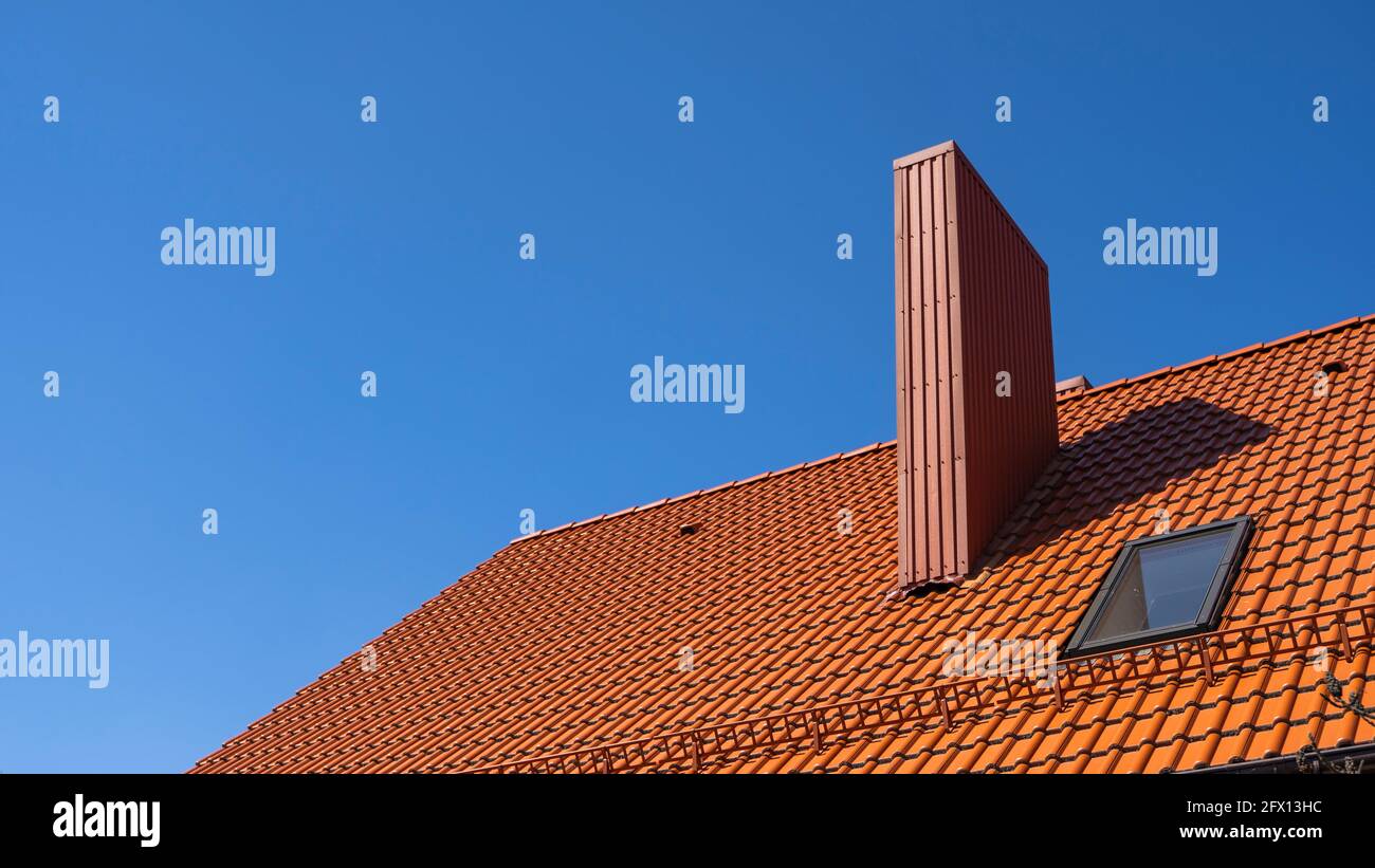 Red corrugated metal profile roof installed on a modern house. The roof ...