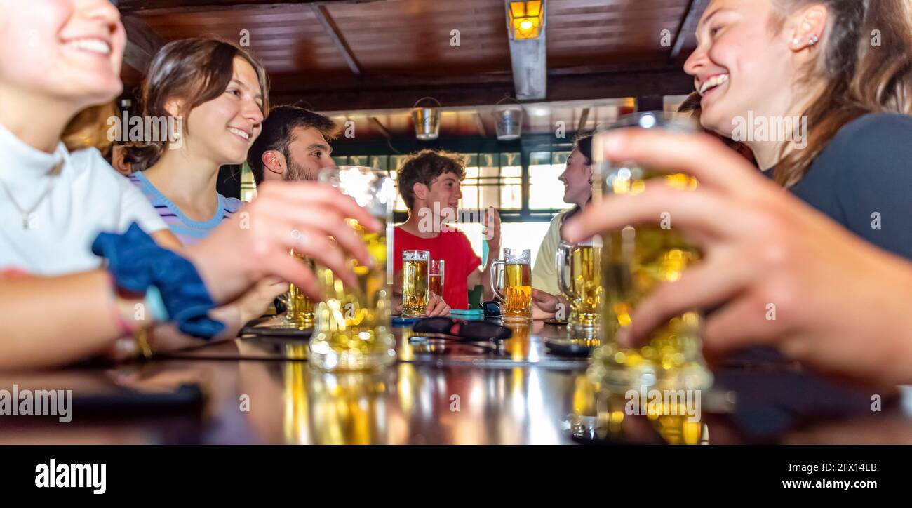 Group of millennials happy friends drinking beer in irish bar ...