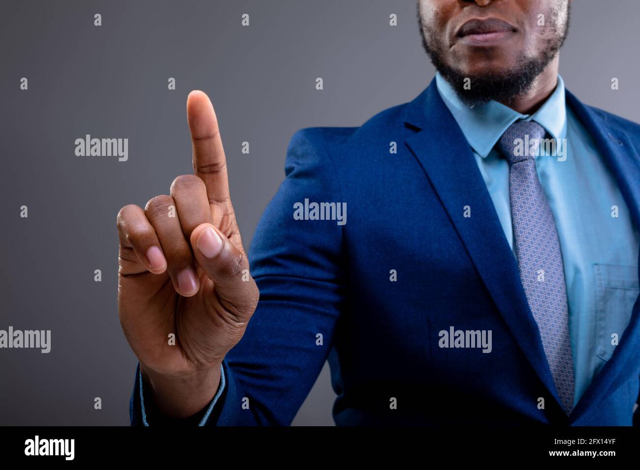 Mid section of african american businessman touching invisible screen ...