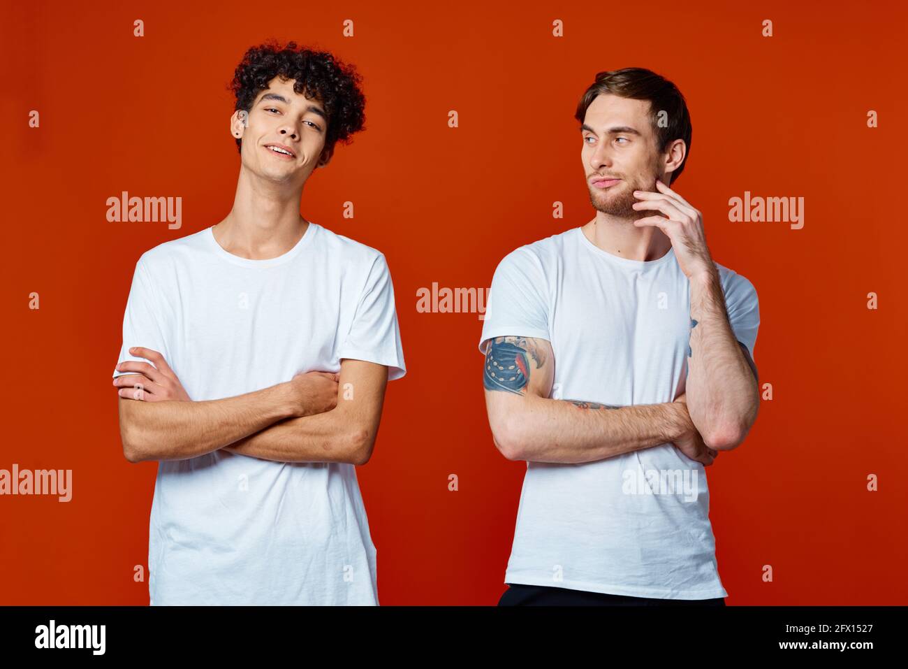 two friends in white t-shirts communication lifestyle red background ...
