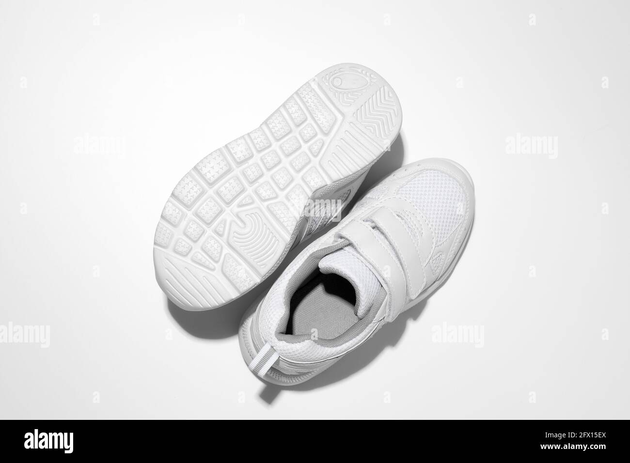 macro top view Two white woman sneakers, one sneaker lies sole up with ...