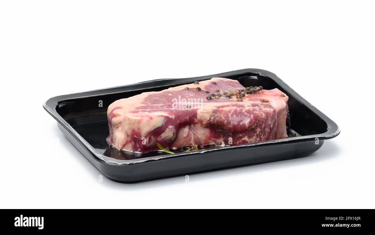 Raw New York beef steak is packed in a plastic container and vacuum ...