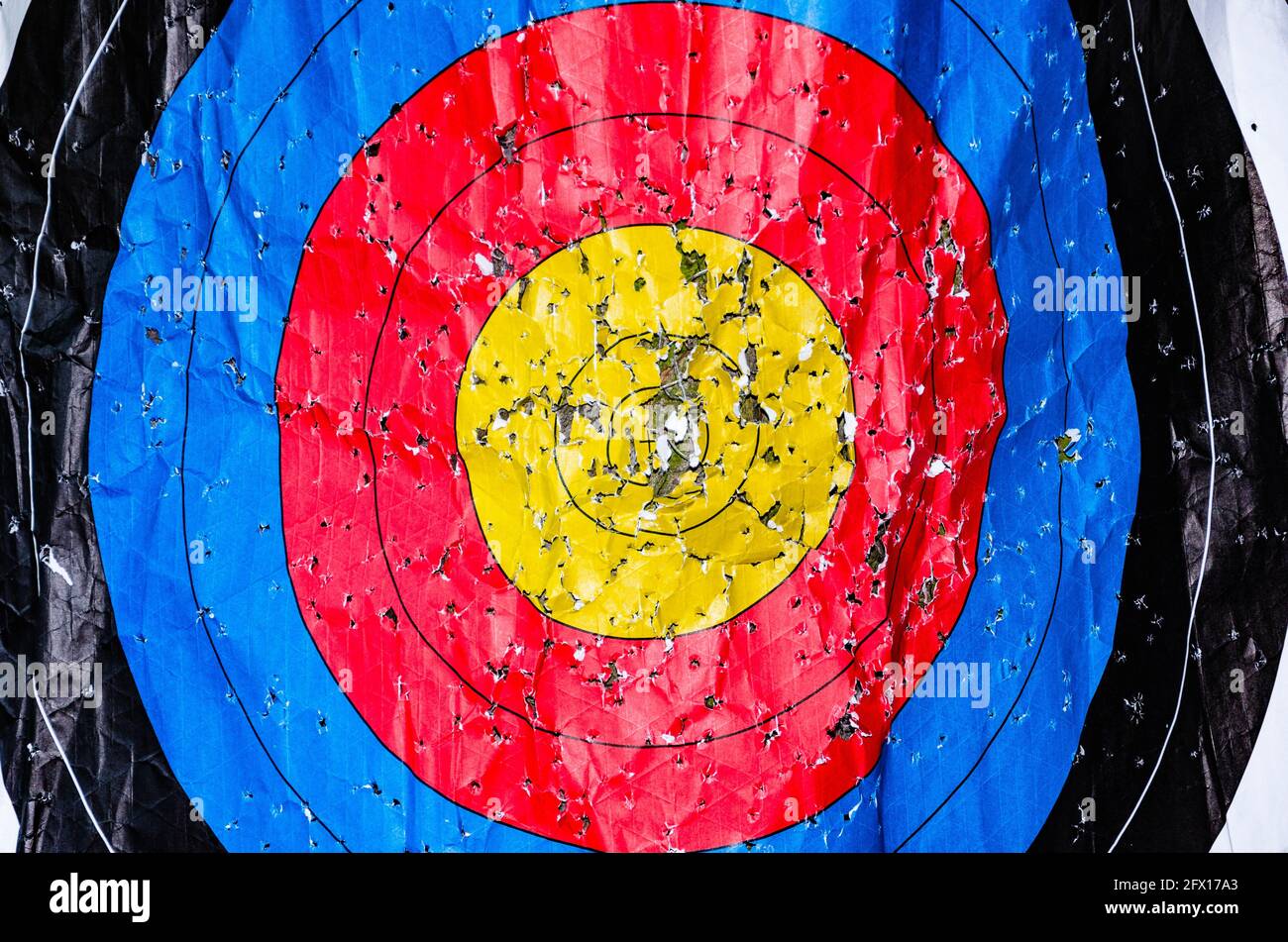 Used paper arrow target full of holes Stock Photo - Alamy