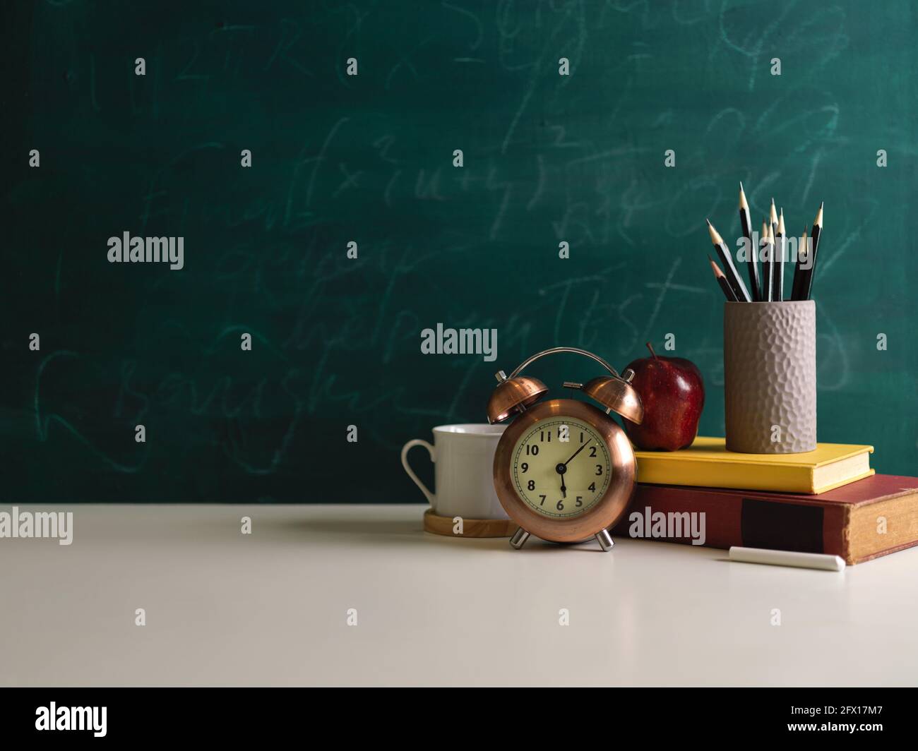 Close up view of study table with school elements, cup, clock and copy ...