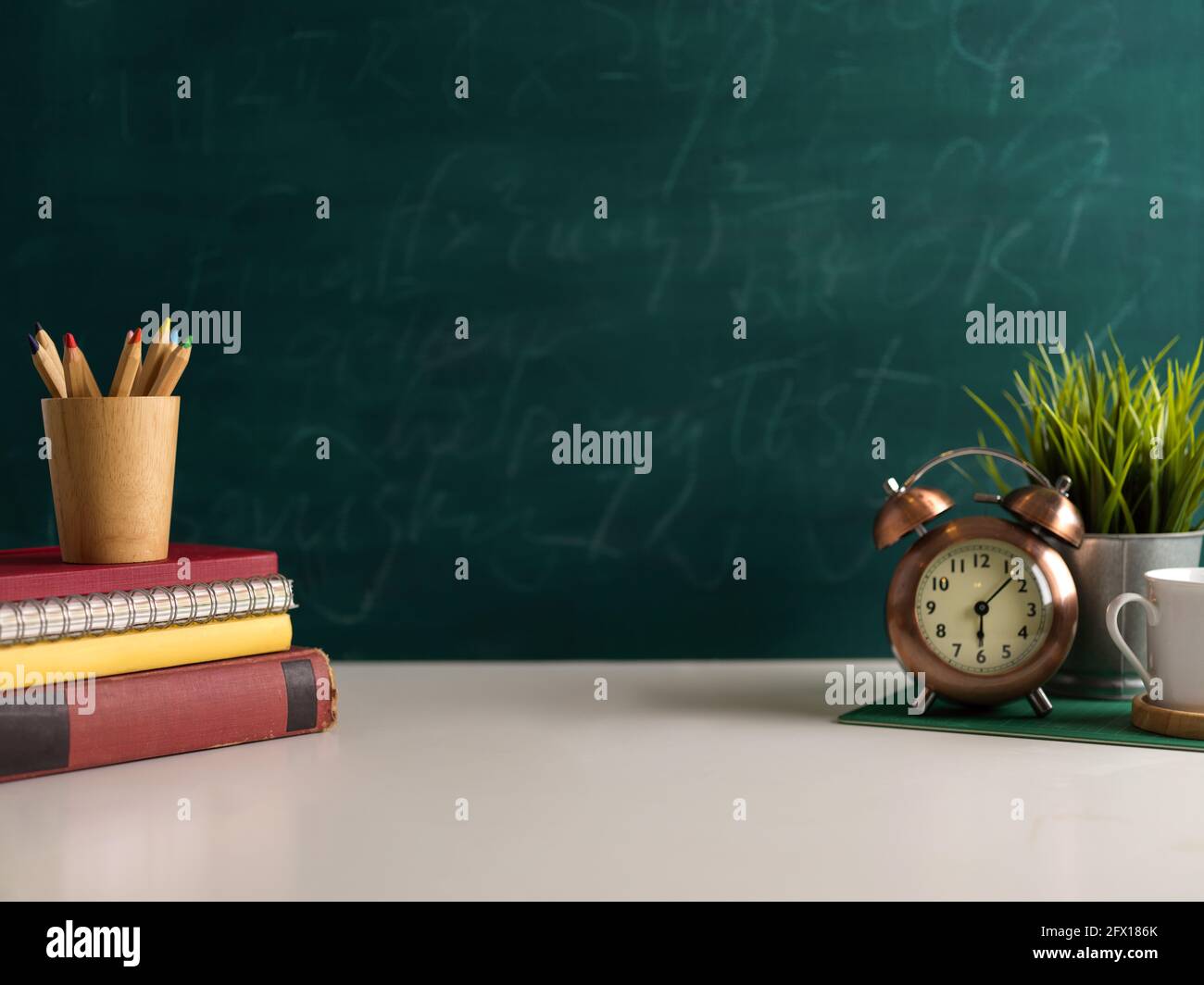 Close up view of study table with school elements, cup, clock and copy ...