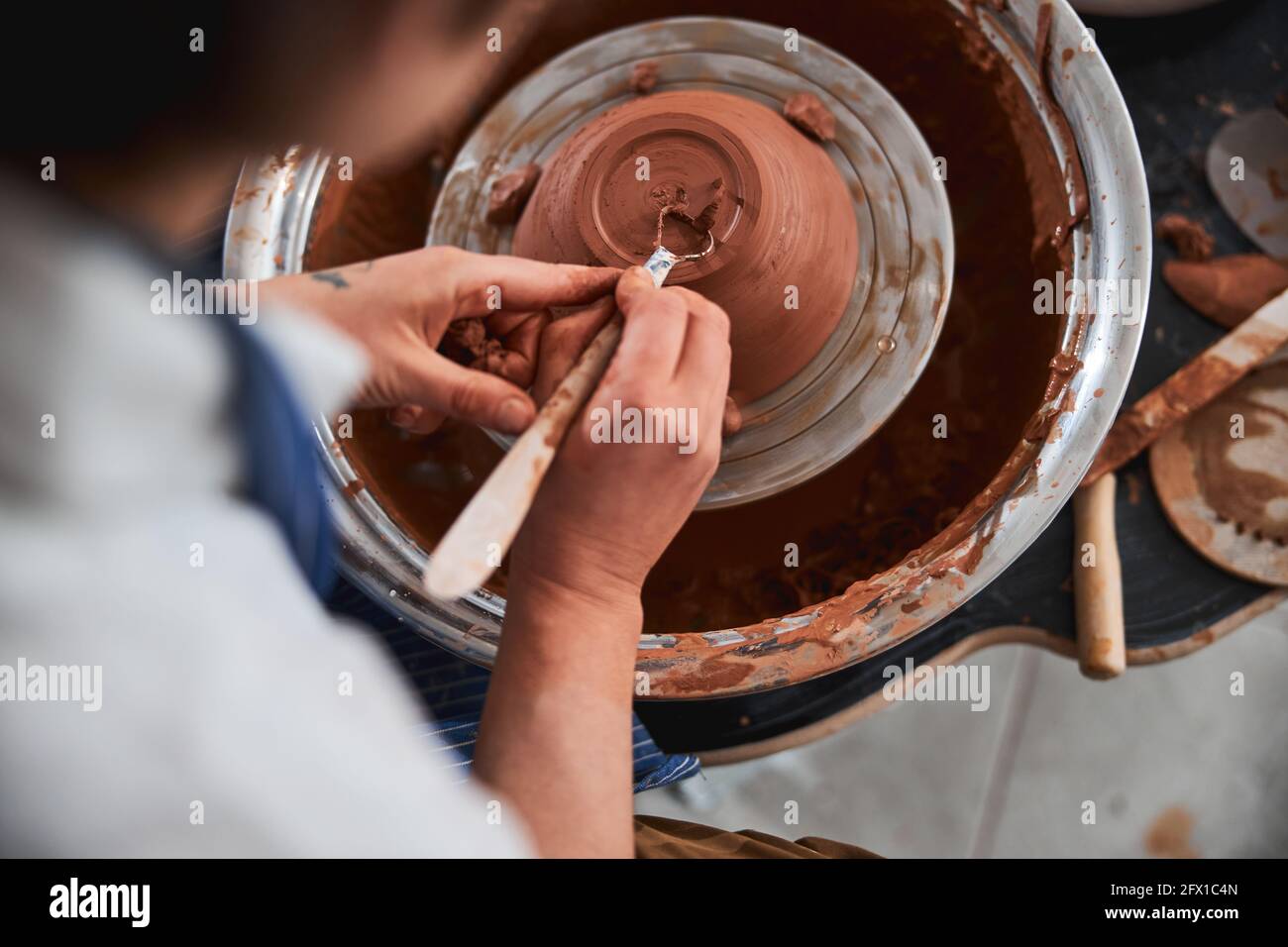 Loop tool taking off clay slice from bowl bottom Stock Photo - Alamy