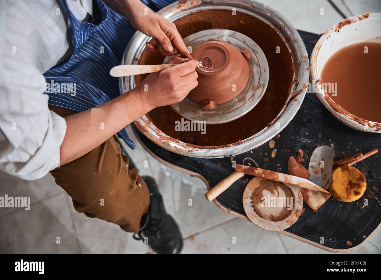 Pottery master forming the back of clay bowl with instrument Stock ...