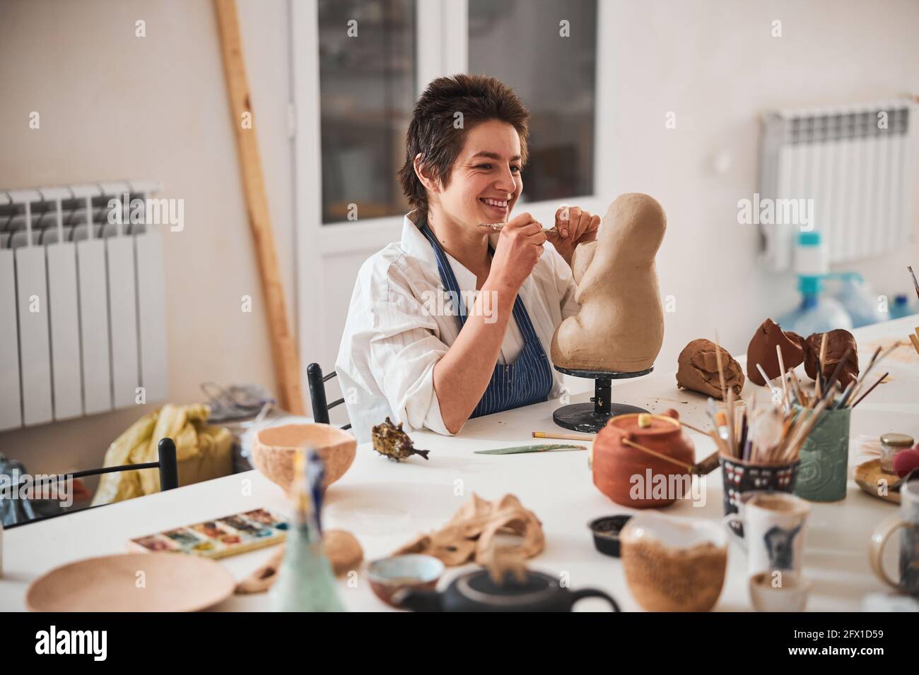 Joyful pottery designer preparing blade of her carver Stock Photo - Alamy