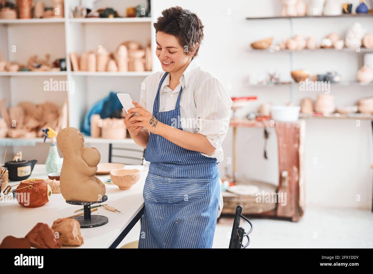 Proud pottery master photographing her work result Stock Photo - Alamy