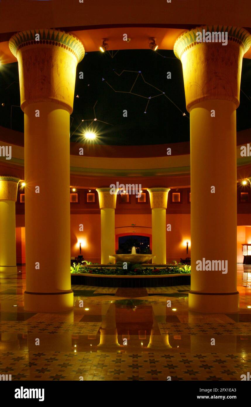 Interior of hotel reception with columns reflected in tiled floor ...