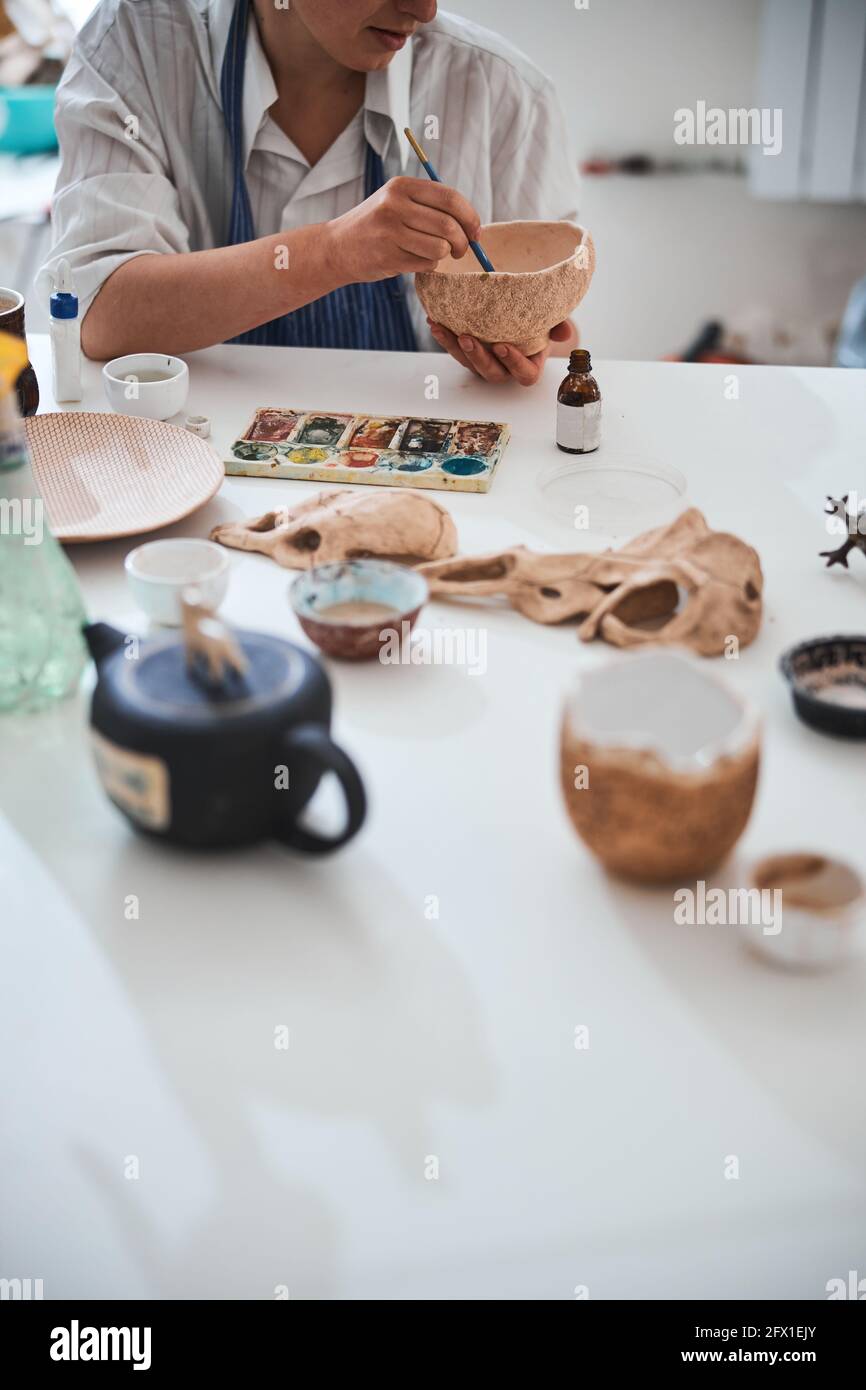 Pot maker covering bowl interior with drawings Stock Photo - Alamy