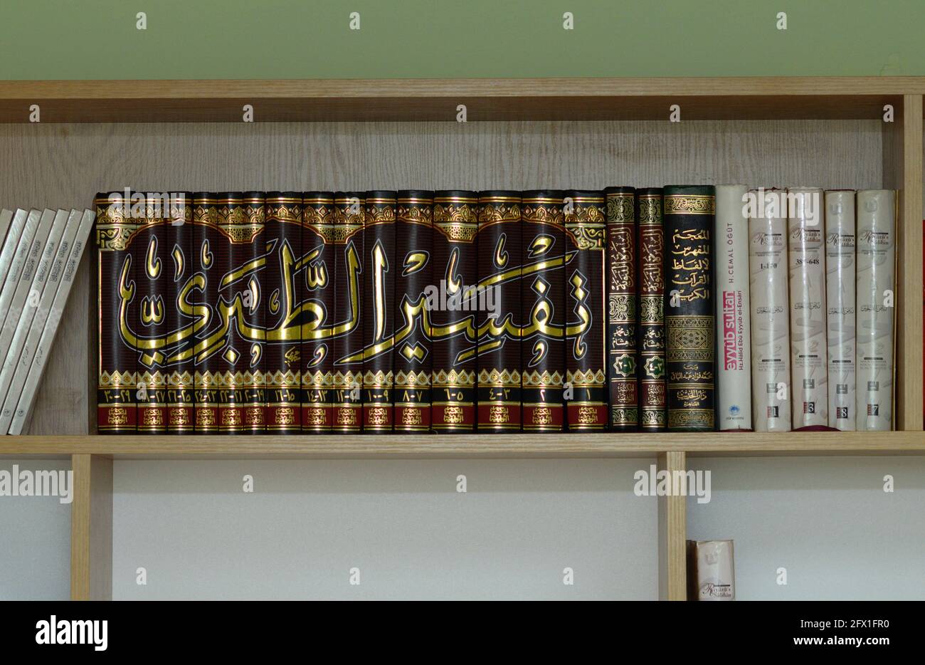 Volumes of Islamic religion books placed on a shelf of a school library ...