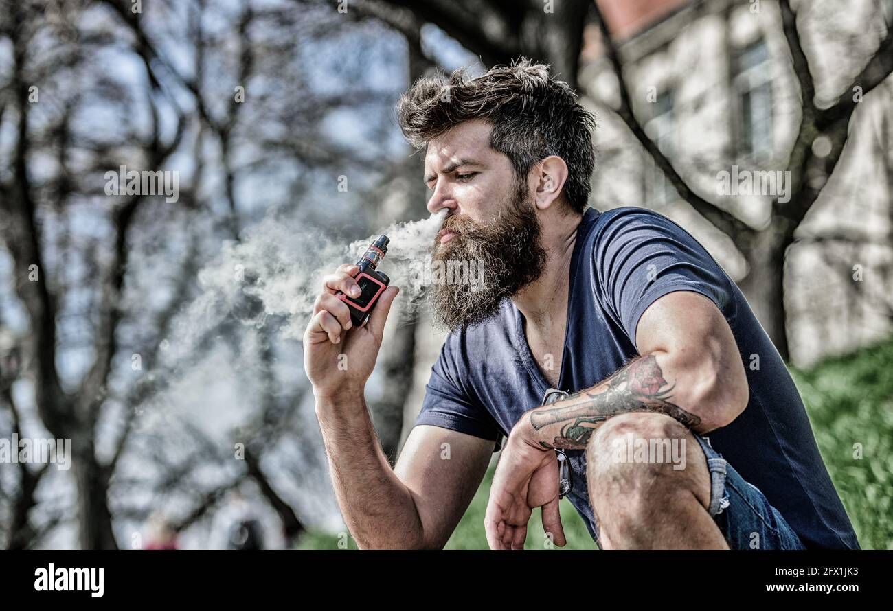 Man with beard breathe out smoke. Clouds of flavored smoke. Stress ...
