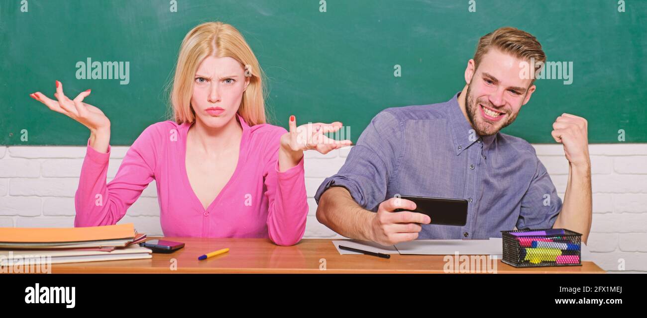 Guy and girl carefree sit at desk in classroom. Studying in college or ...