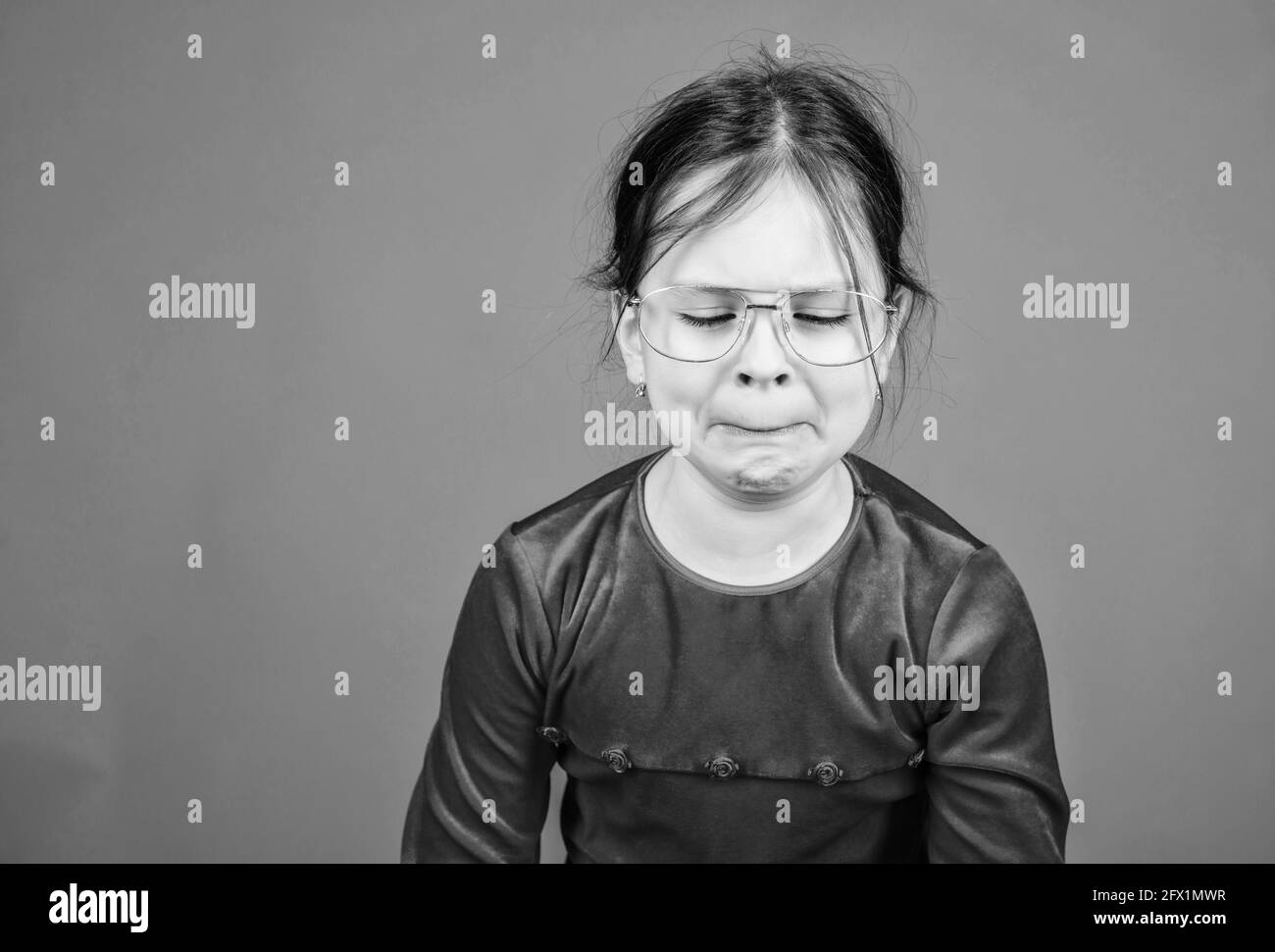 Desperate baby. Emotional face small girl violet background. Can not ...