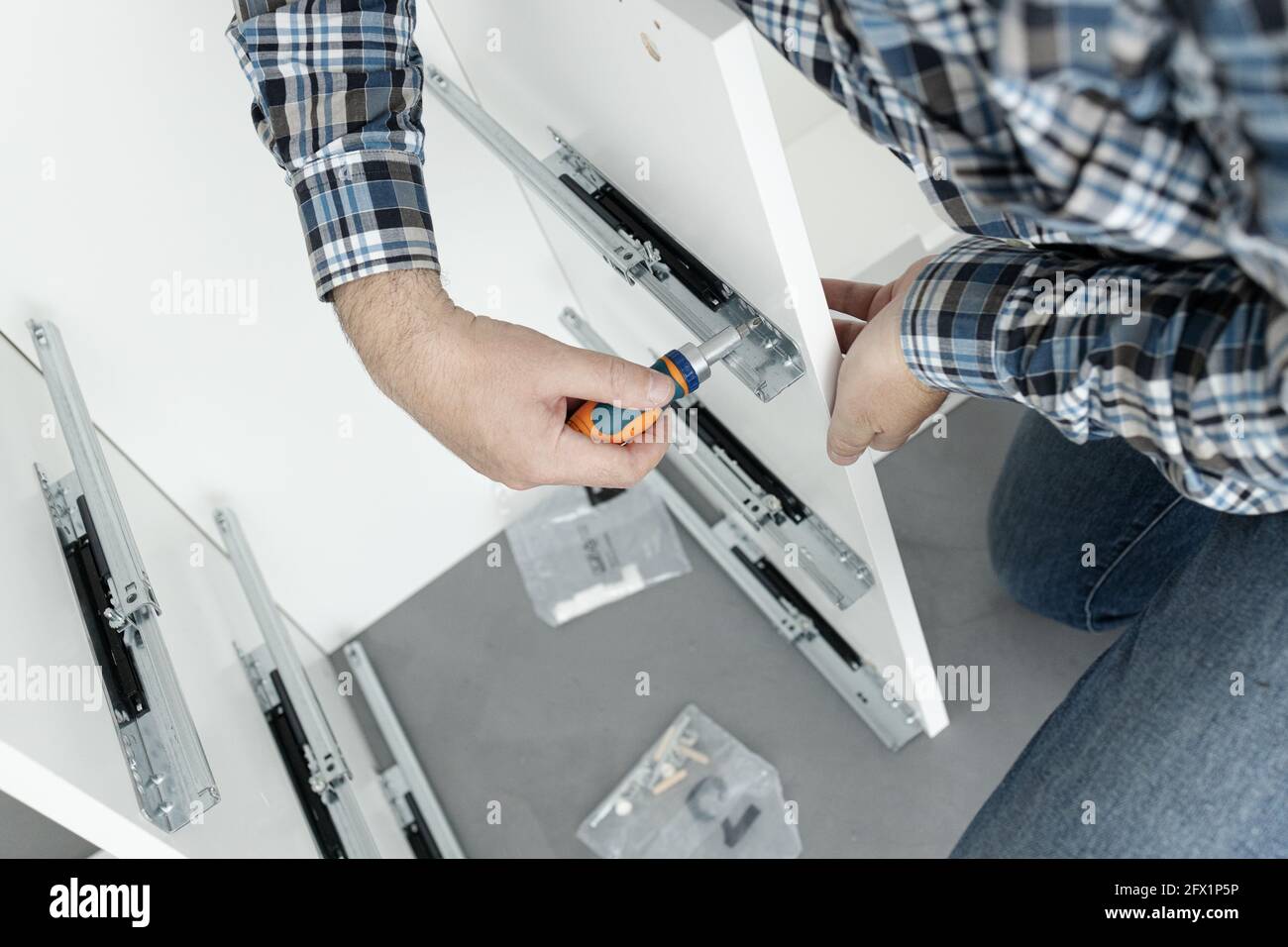 Man Assembling a drawer slider Furniture using a screwdriver Stock ...