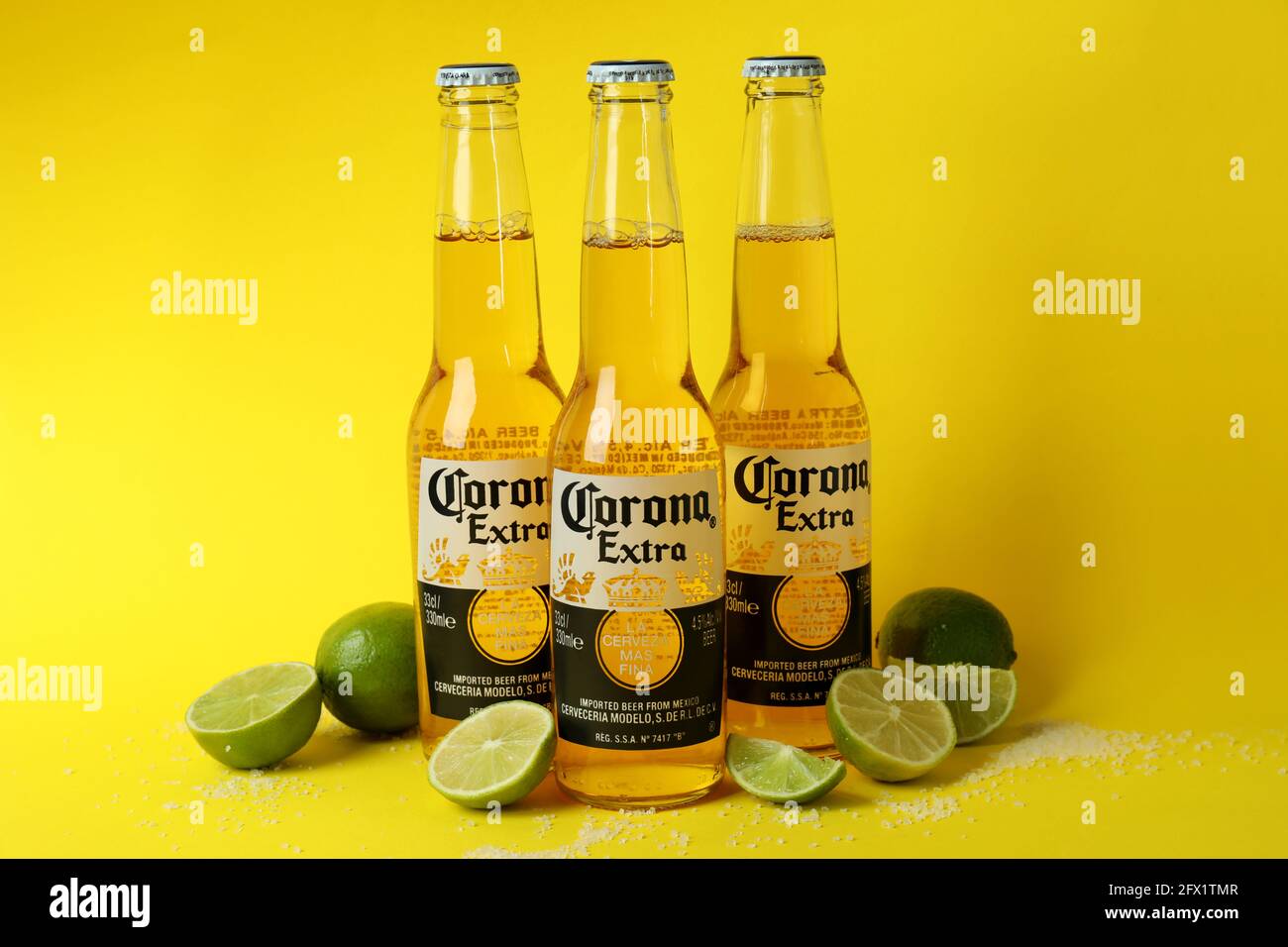 Bottles of Corona Extra, limes and salt on yellow background Stock ...