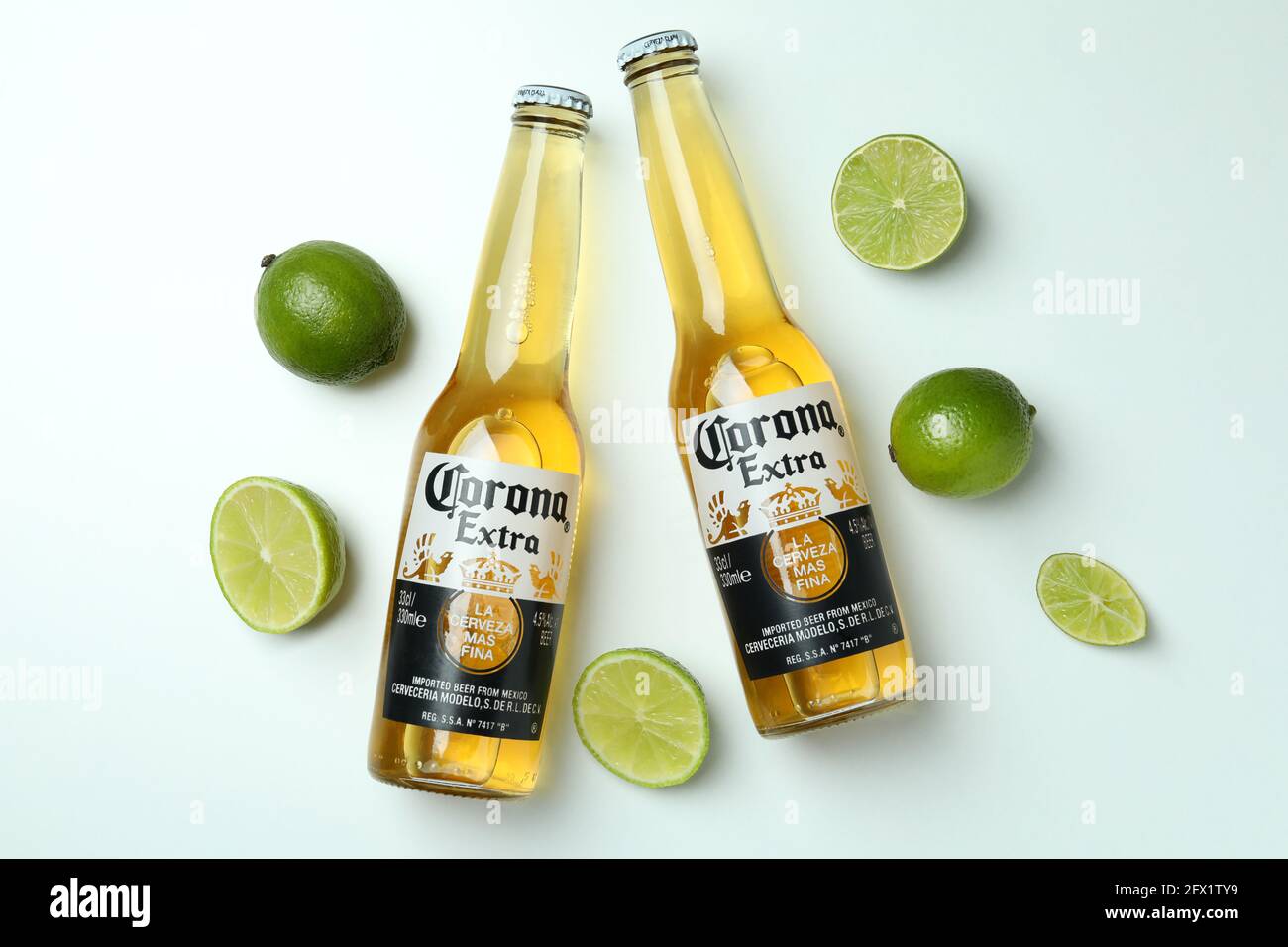 Bottles of Corona Extra and limes on white background Stock Photo - Alamy