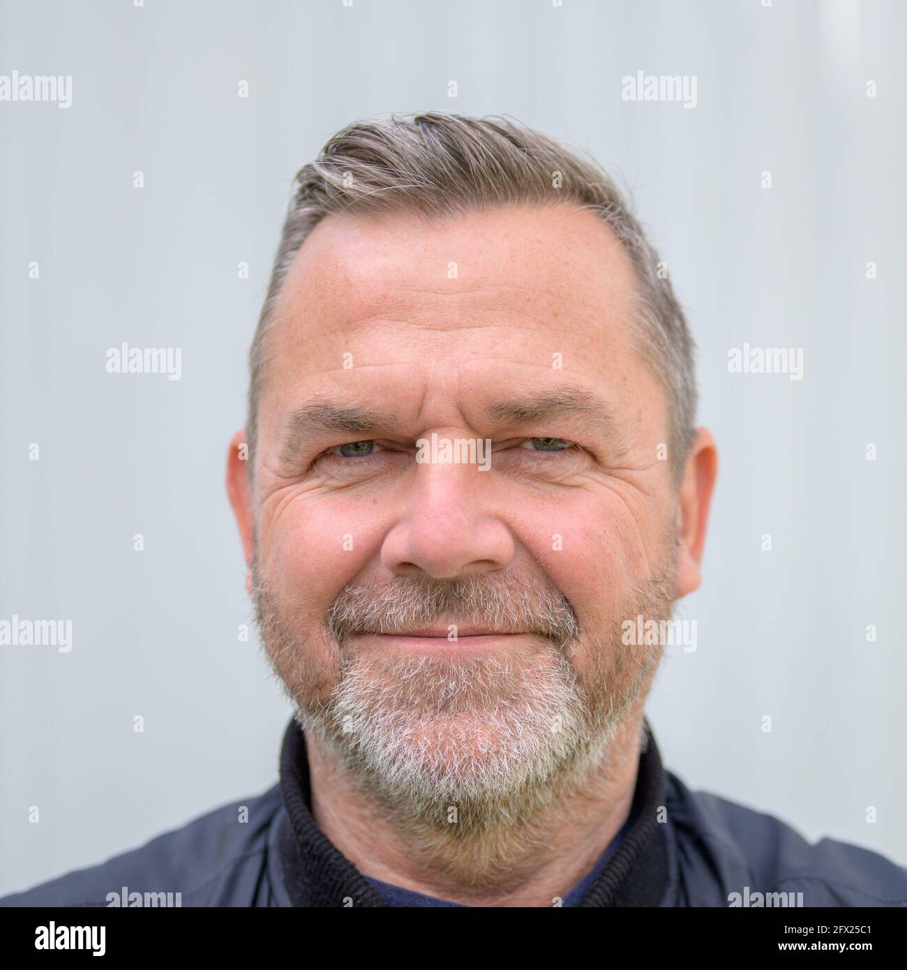 Happy middle-aged man looking at camera with a big smile as he poses in ...