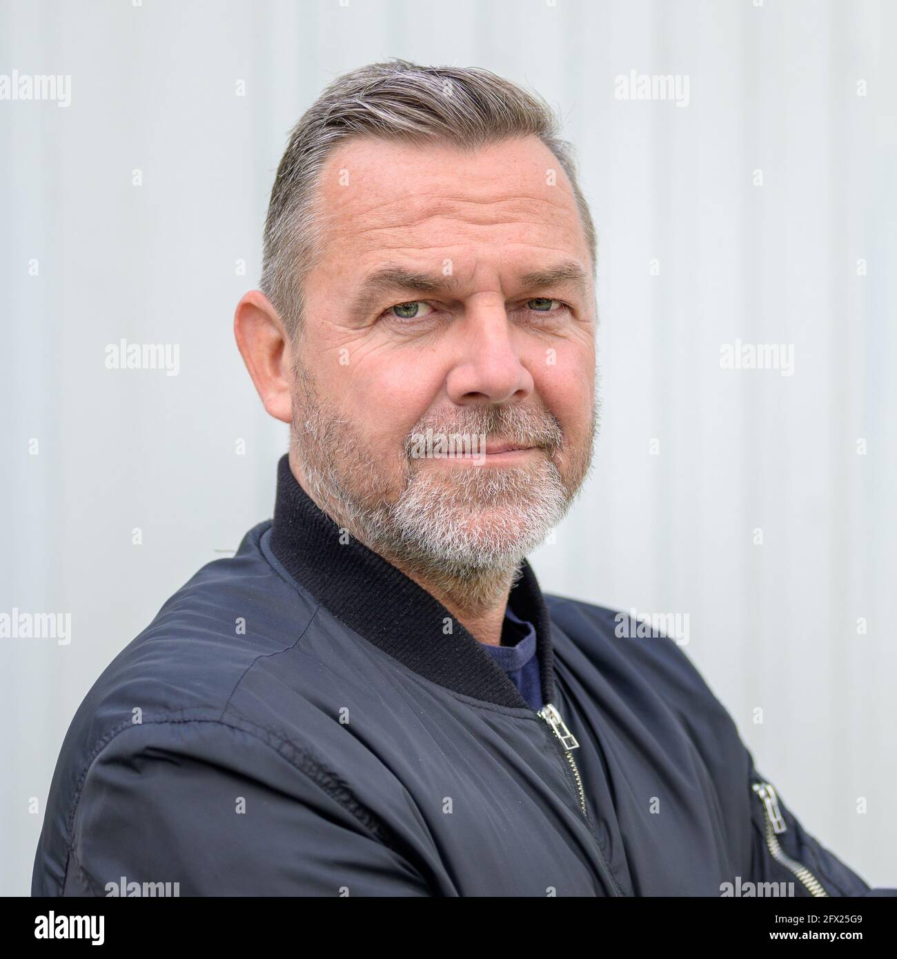 Serious middle-aged man turning and looking pensively at the camera ...