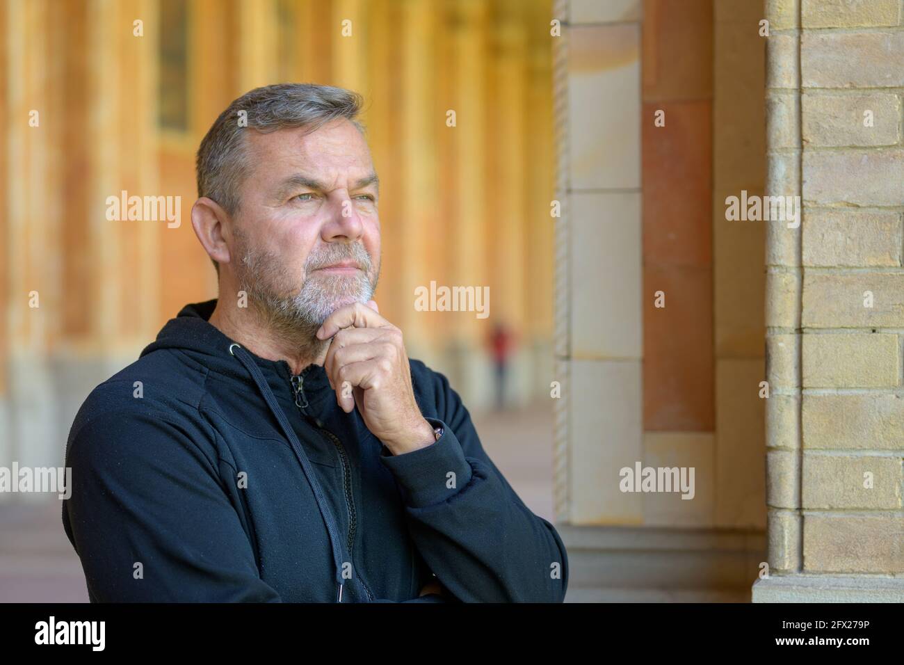 Man standing deep in thought with a concerned expression as he looks ...