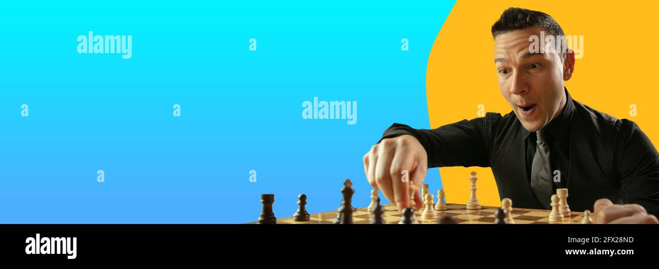 One Caucasian man chess player playing chess alone isolated over blue ...
