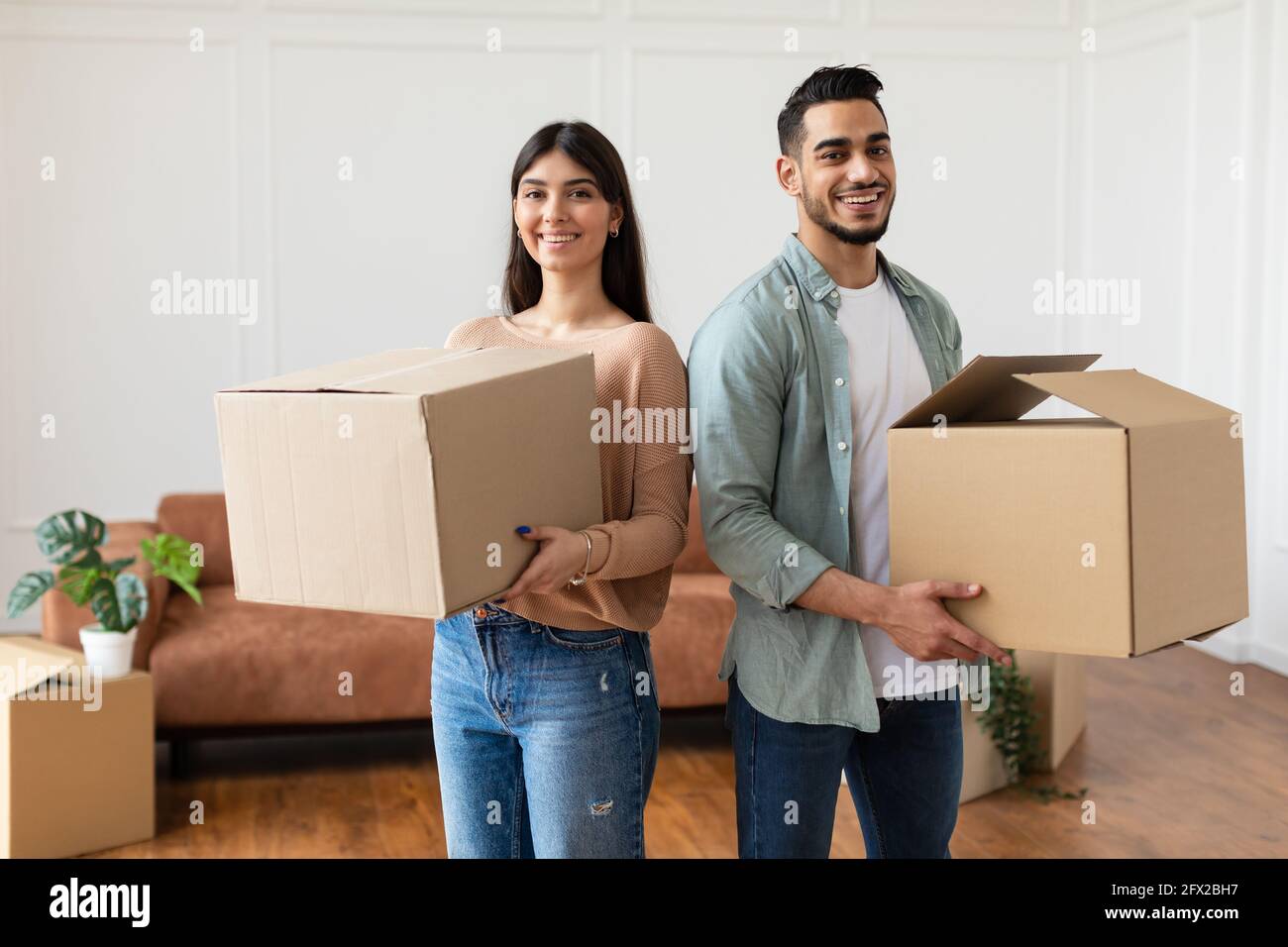Happy man and woman holding cardboard boxes Stock Photo - Alamy