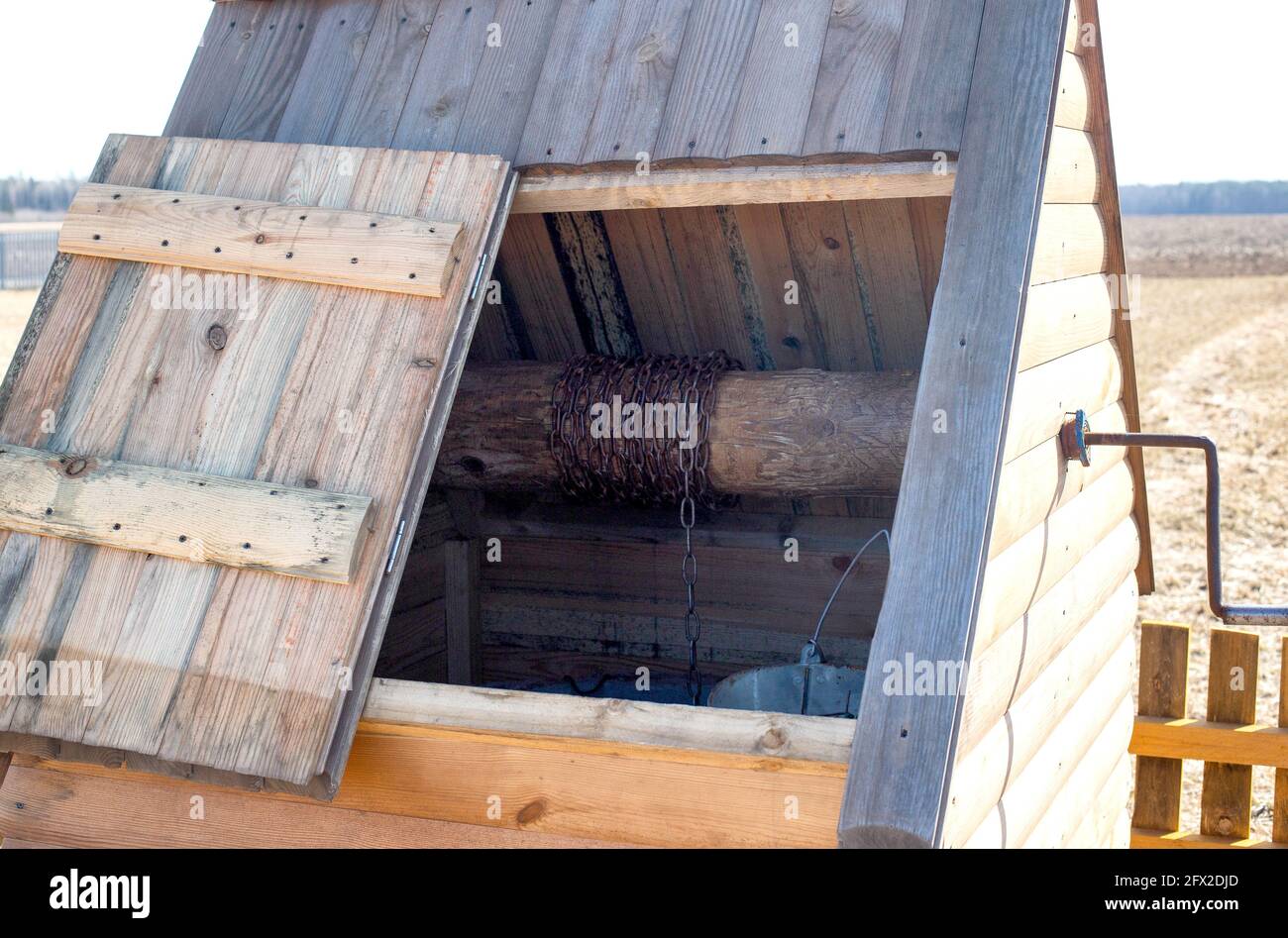 Beautiful and modern wooden well with water in a village in nature ...