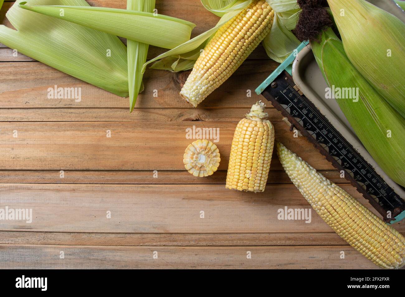Green corn arranged on a wooden table and a scale. Top view Stock Photo ...