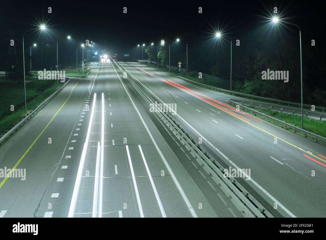 Country night track lit by lanterns. It shows streaks of light from the ...