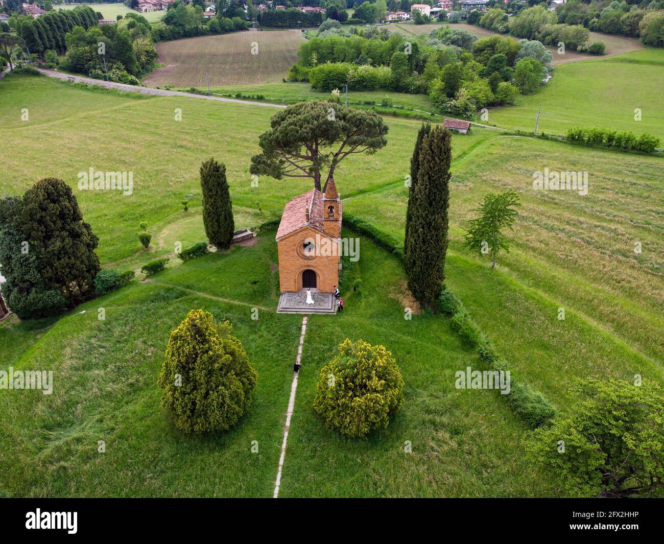 Drone view of freshly married couple at the red church of Pomelasca ...