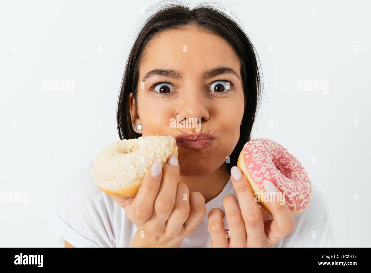 Portrait of funny young happy woman eating sweets donuts, white ...